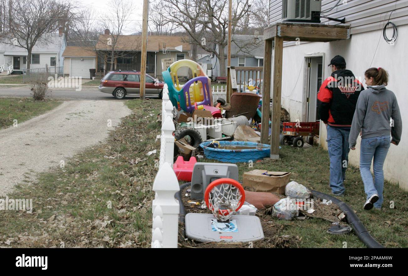 Wade Monnig, left, and his sister Mandy walk through his yard where flood waters deposited ...