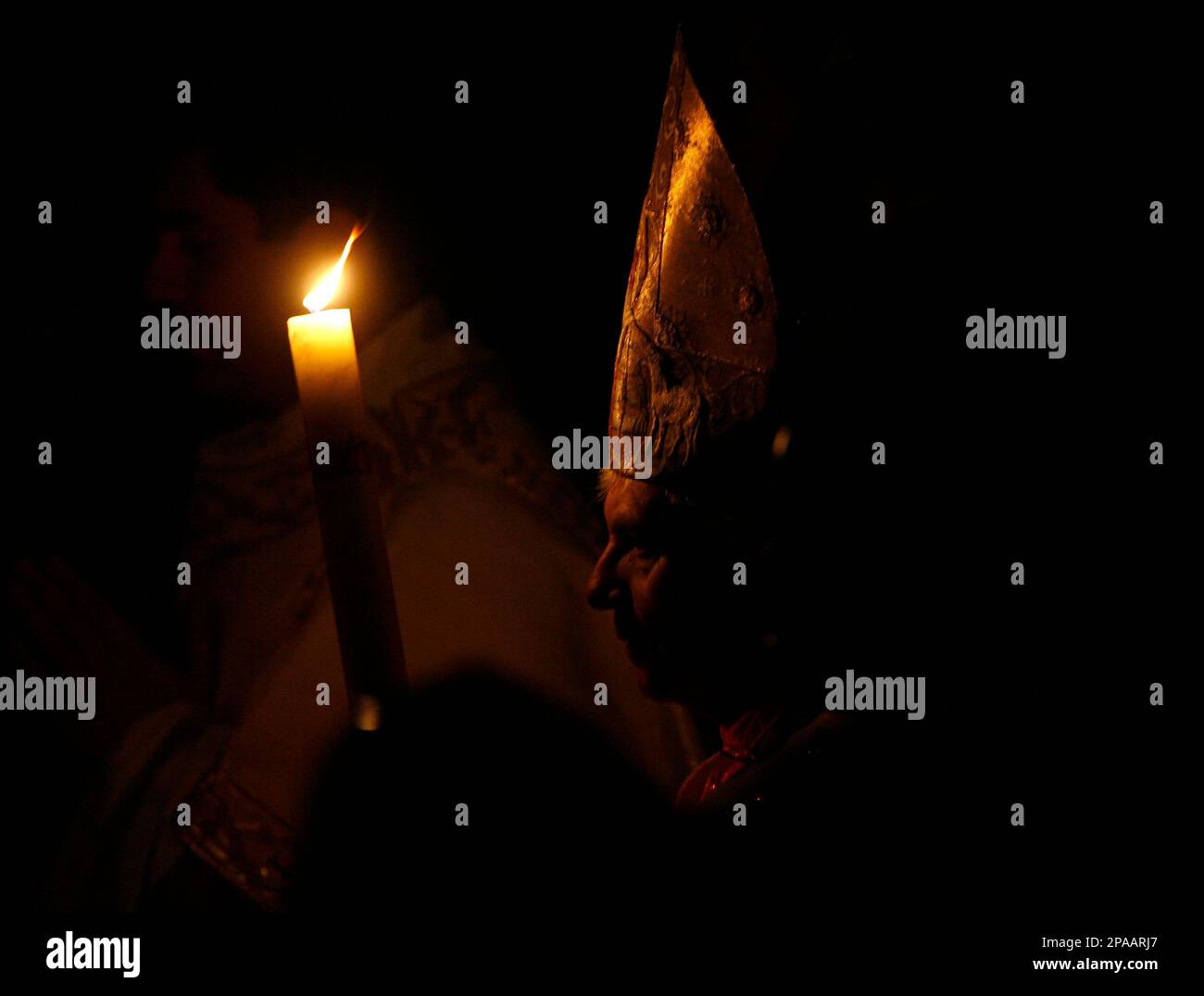 Pope Benedict XVI holds a candle during the Easter vigil mass in St ...