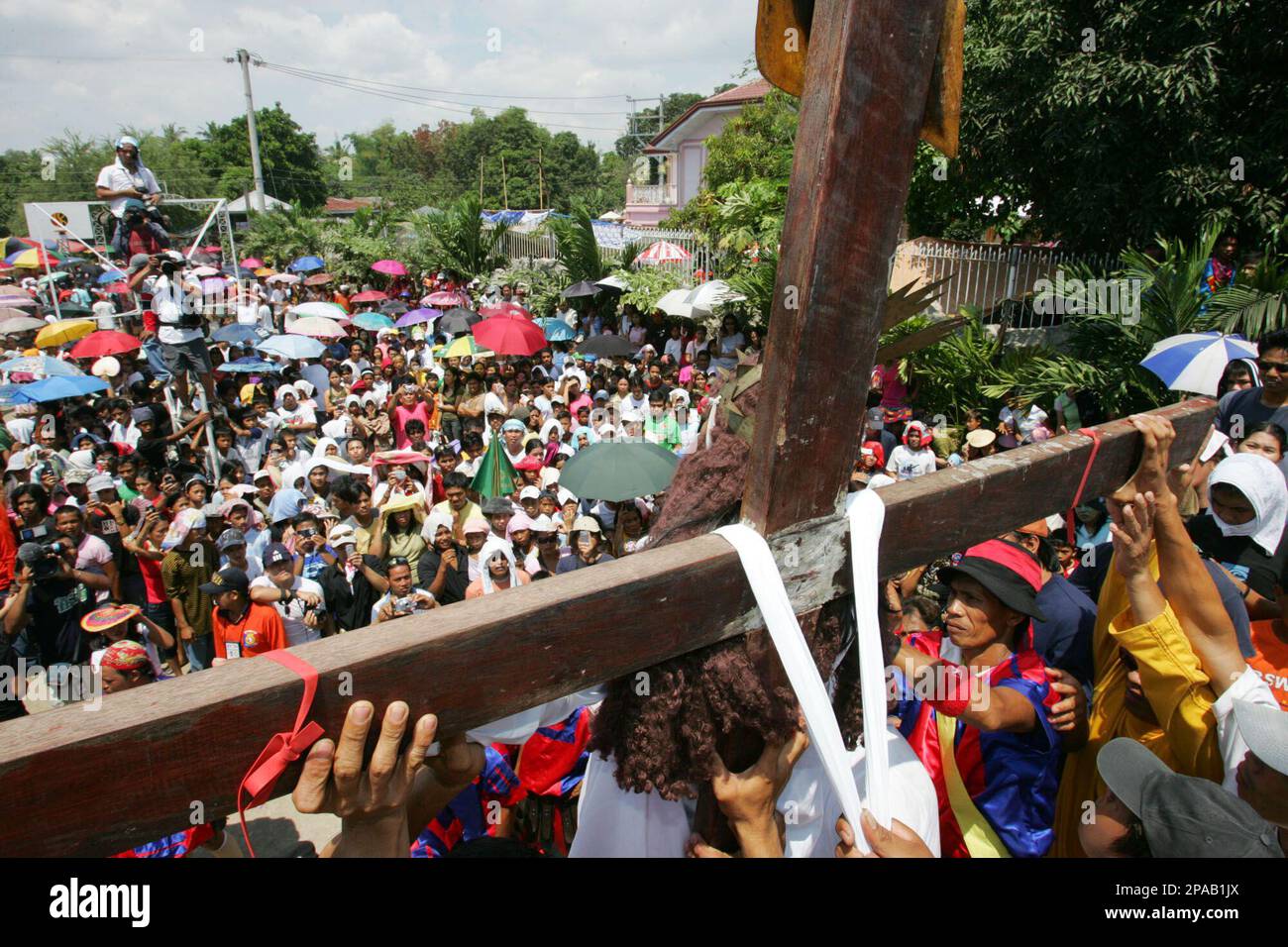 A big crowd of Filipino pilgrims watch a reenactment of the crucifixion ...