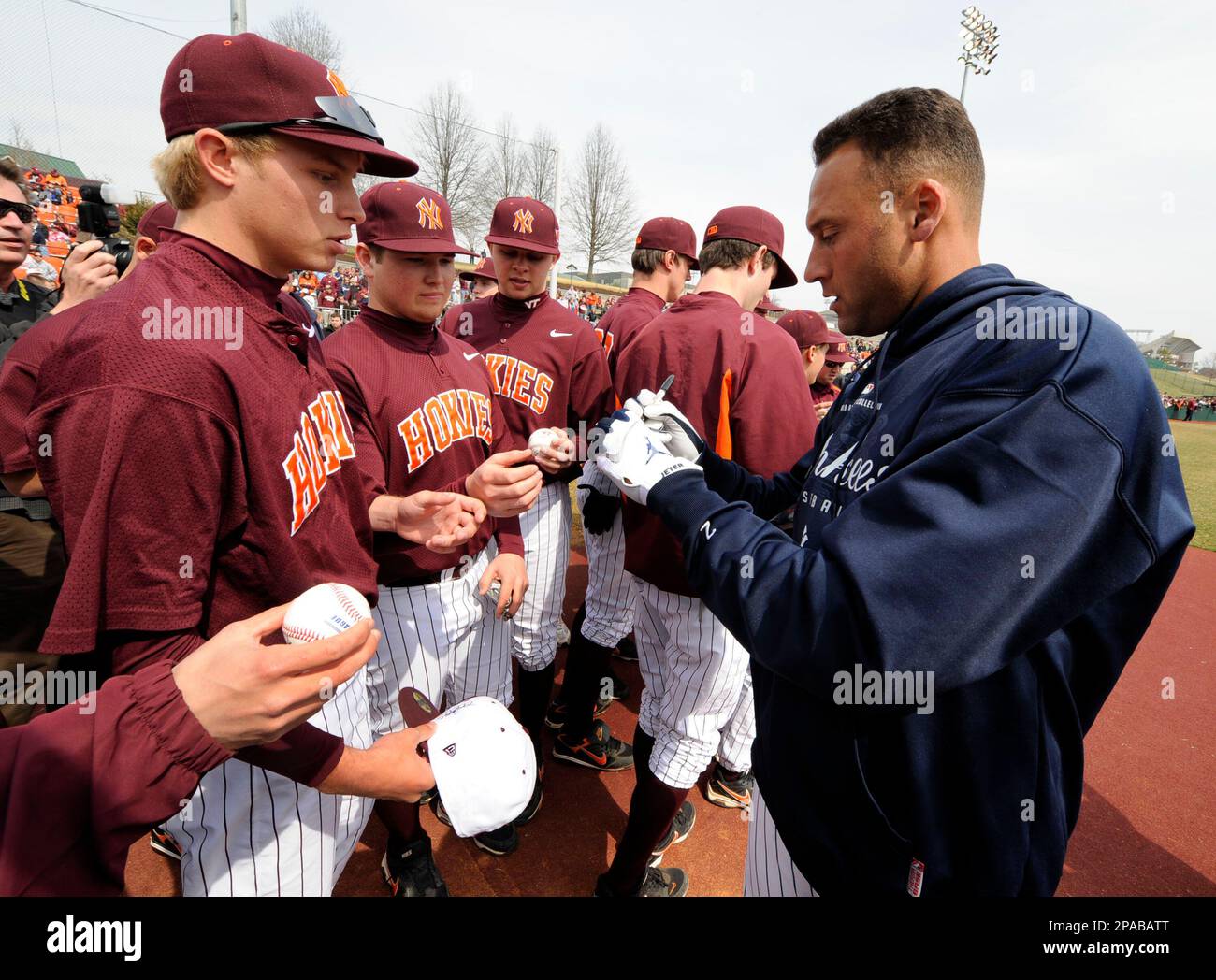 New York Yankees shortstop Derek Jeter, right, signs autographs for the ...