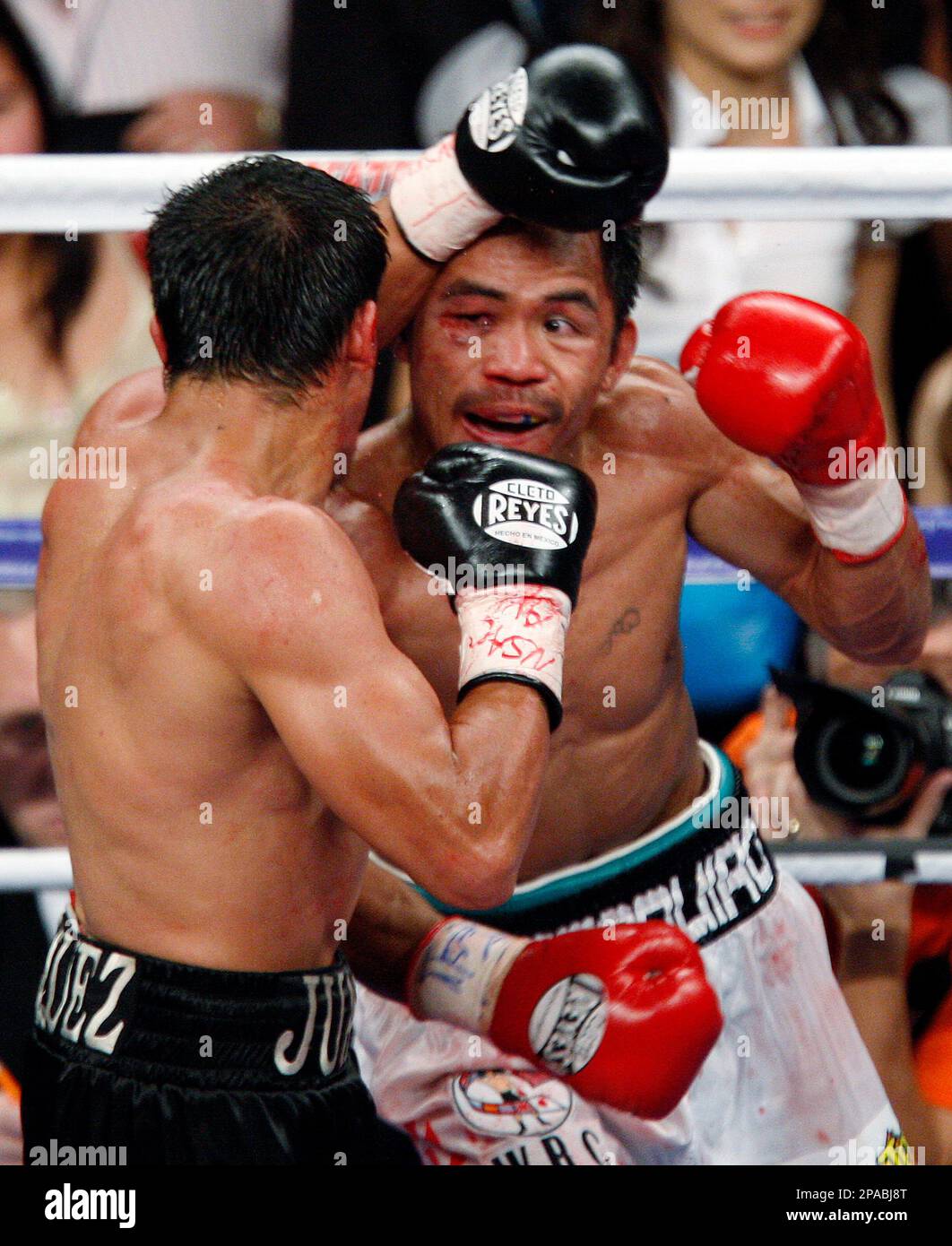 Manny Pacquiao, right, of the Philippines, takes a punch from Juan ...
