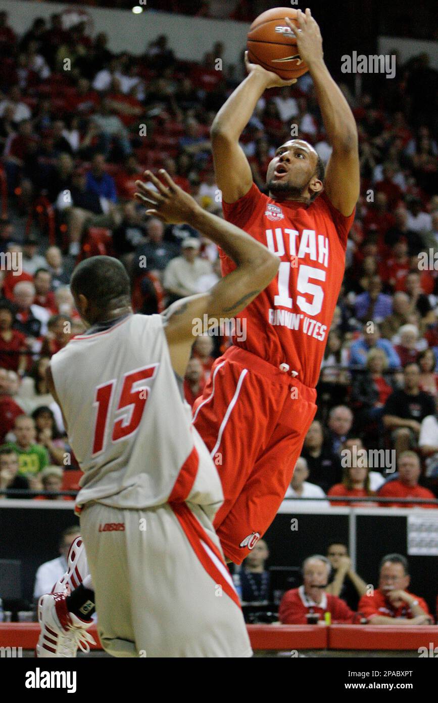 Utah's Carlon Brown shoots over New Mexico's J. R. Giddens during the ...