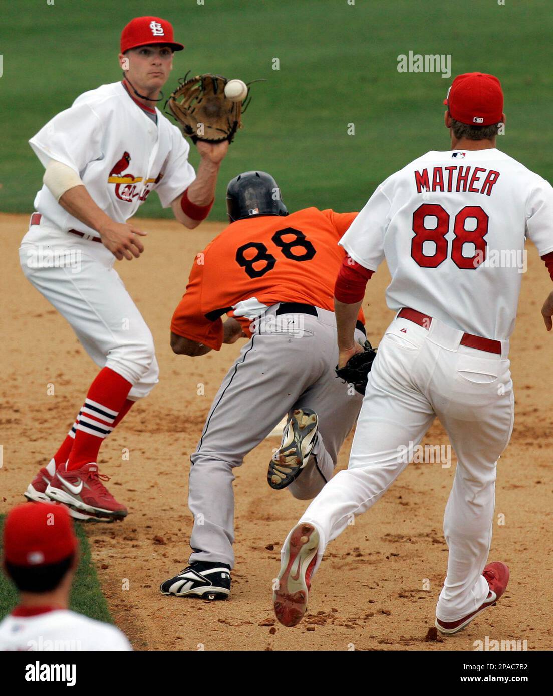 St. Louis Cardinals first baseman Joe Mather, right, tosses the ball to ...