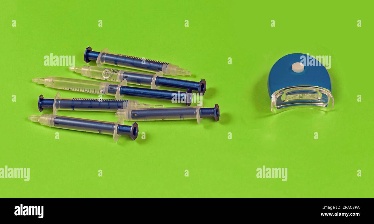 Tooth whitening tools with blue led lamp and plastic syringes filled ...