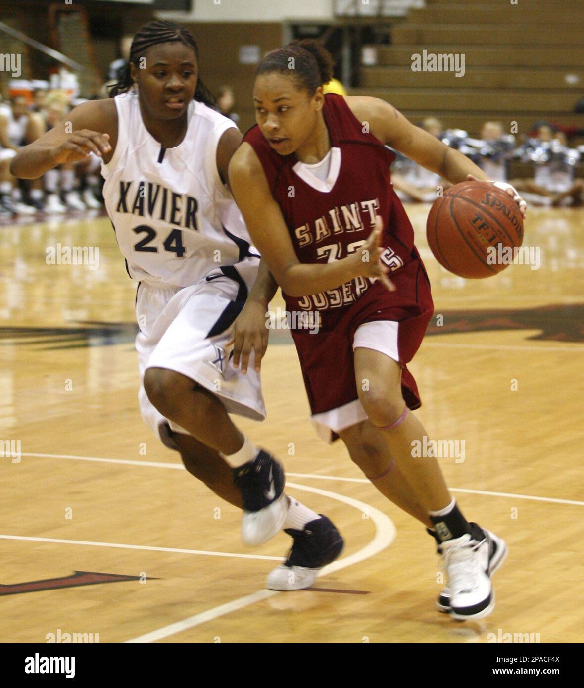 Saint Joseph's Timisha Gomez, right, drives the ball into the lane as ...