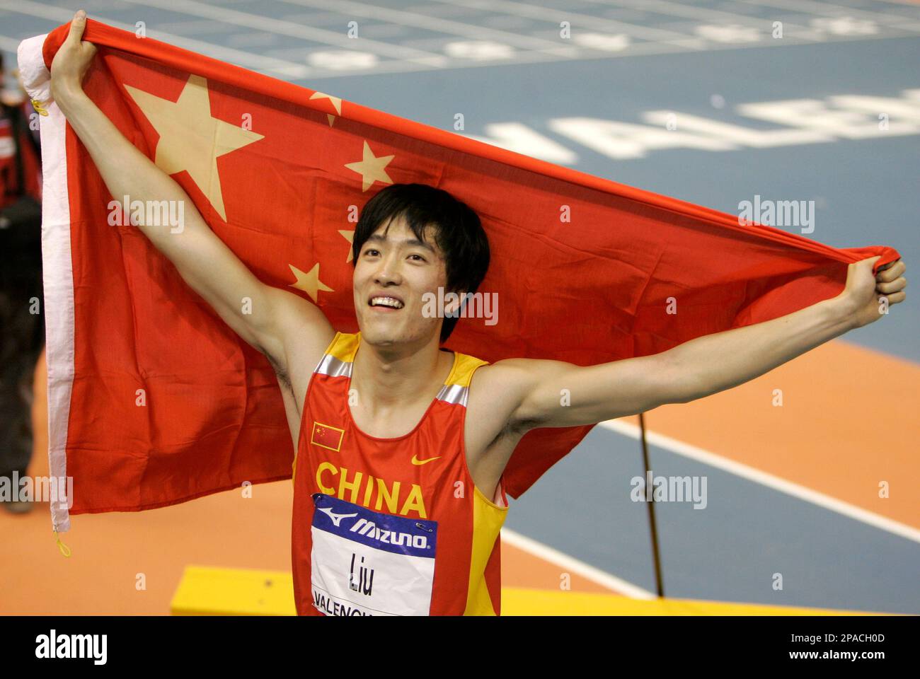 China's Liu Xiang celebrates with the Chinese flag after winning the ...