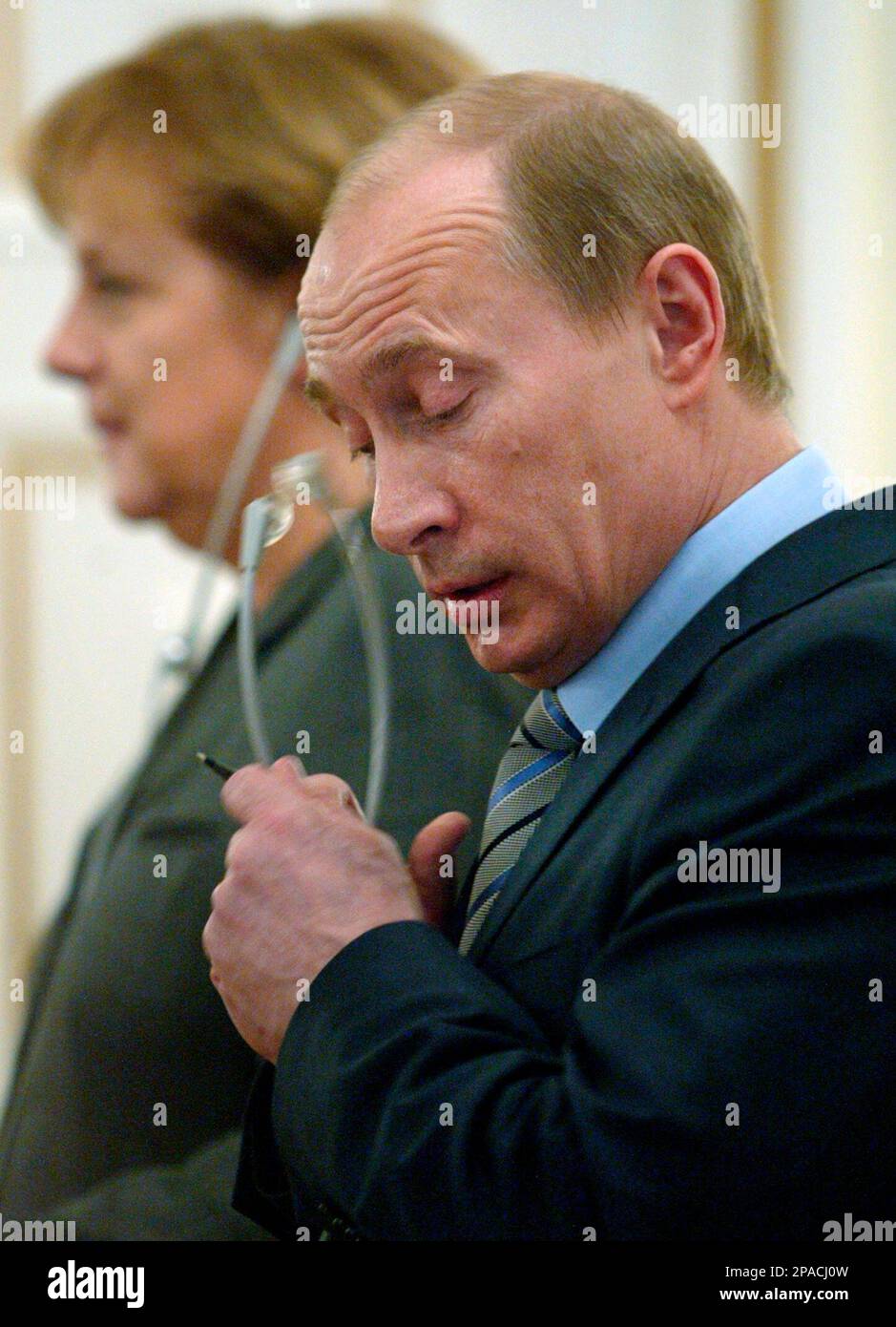 Outgoing Russian President Vladimir Putin right, removes his headphones ...