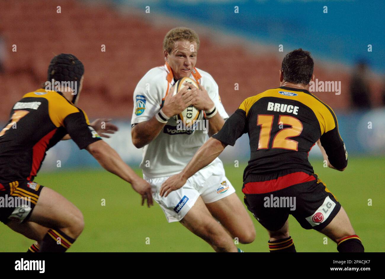 Cheetahs Meyer Bosman, center, splits the Chiefs defense of Tom Harding ...