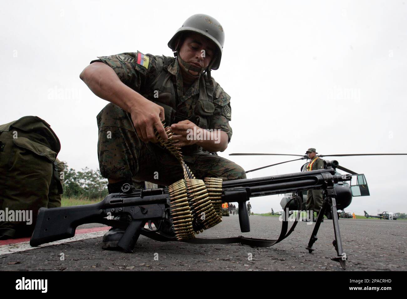 An Ecuadorean soldier prepares his weapon before boarding a helicopter ...