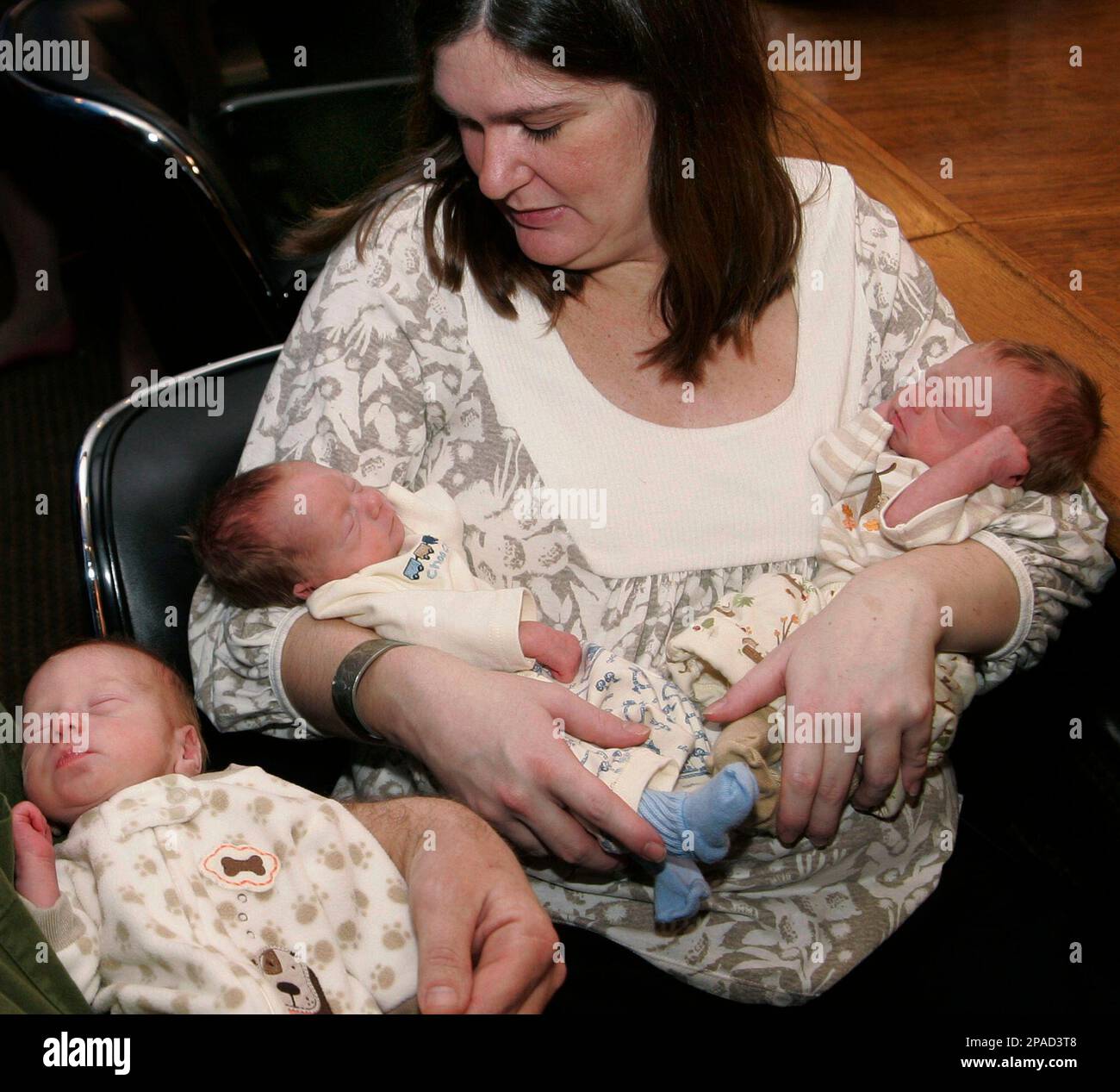 Allison Penn looks at her identical triplets, from left, Logan, Eli and ...