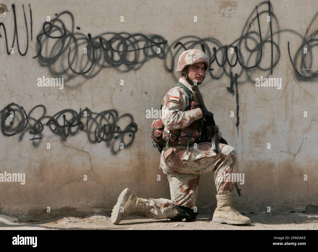 An Iraqi soldier takes a defensive position during a patrol in the ...