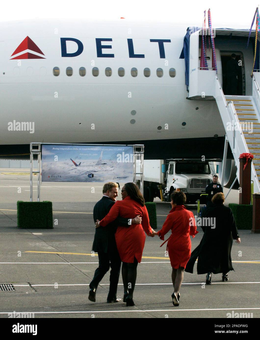 Members of Delta Air Lines Inc. flight crew hug as they walk to board ...