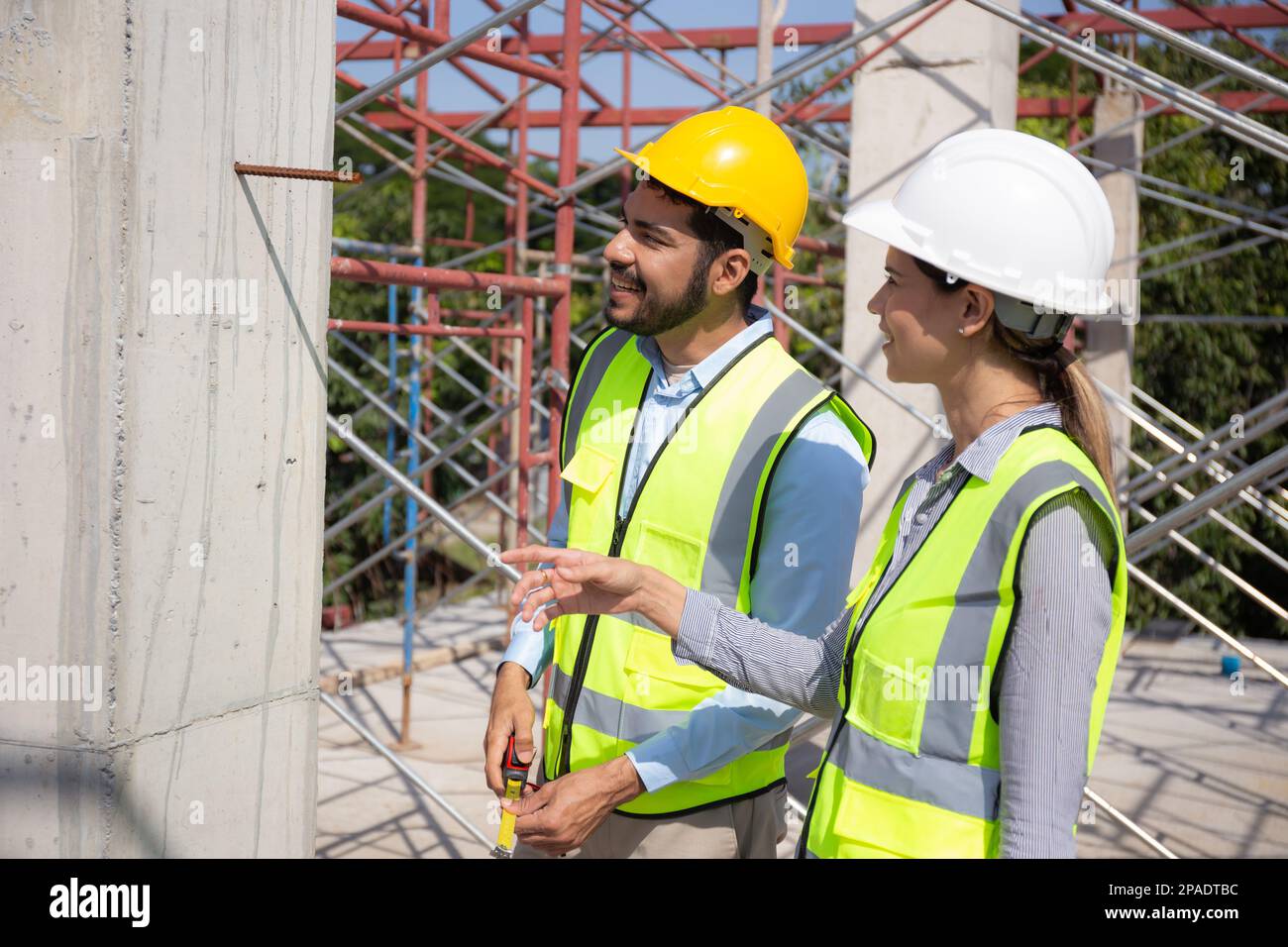 Engineer young man and woman using tape measure for check and examining ...