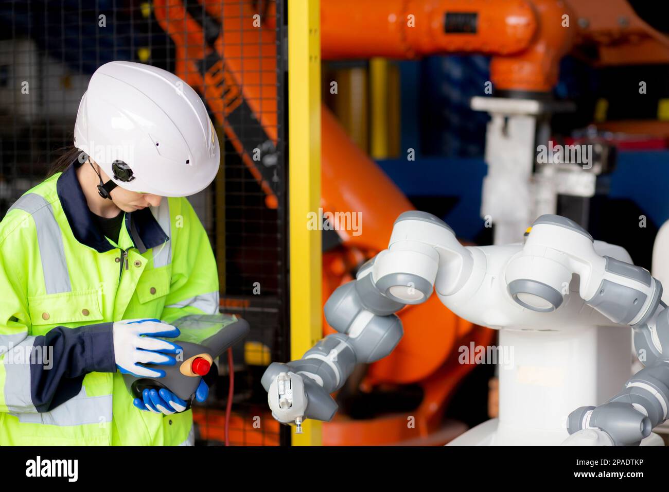 Young engineer woman checking and maintenance machine robot arms technology intelligence and ...