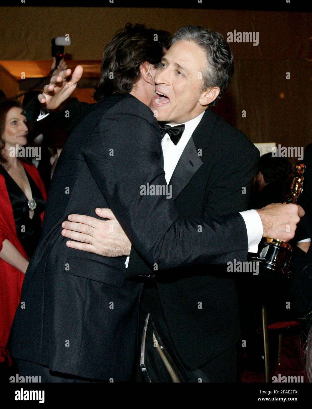Jon Stewart, right, hugs Academy Award winner Javier Bardem as Bardem holds his best supporting ...