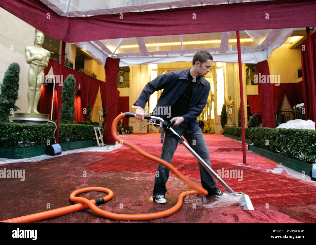 Josh Santibanez tries to vacuum water out of the red carpet outside the ...