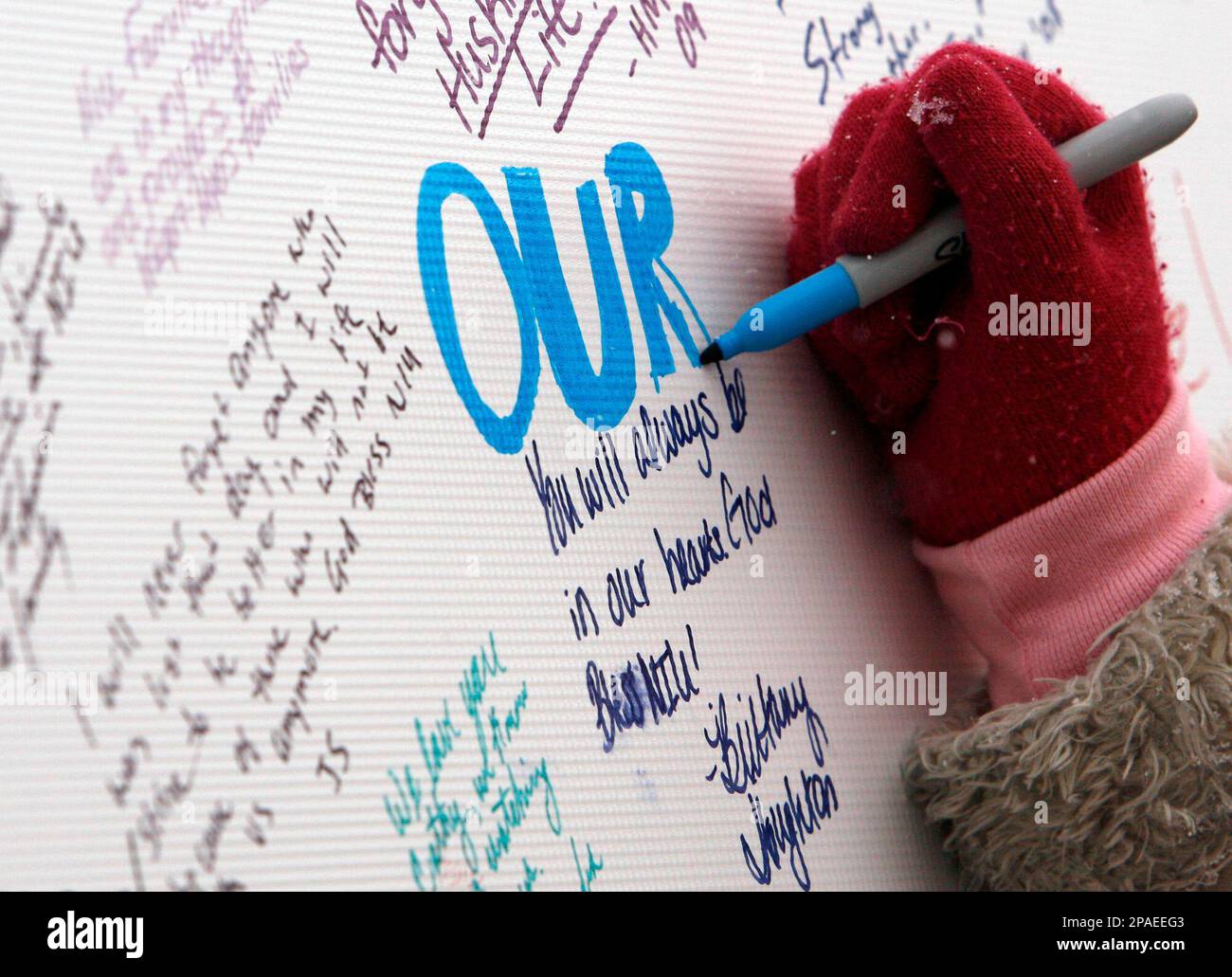 A student writes a message on a makeshift memorial for those killed at ...