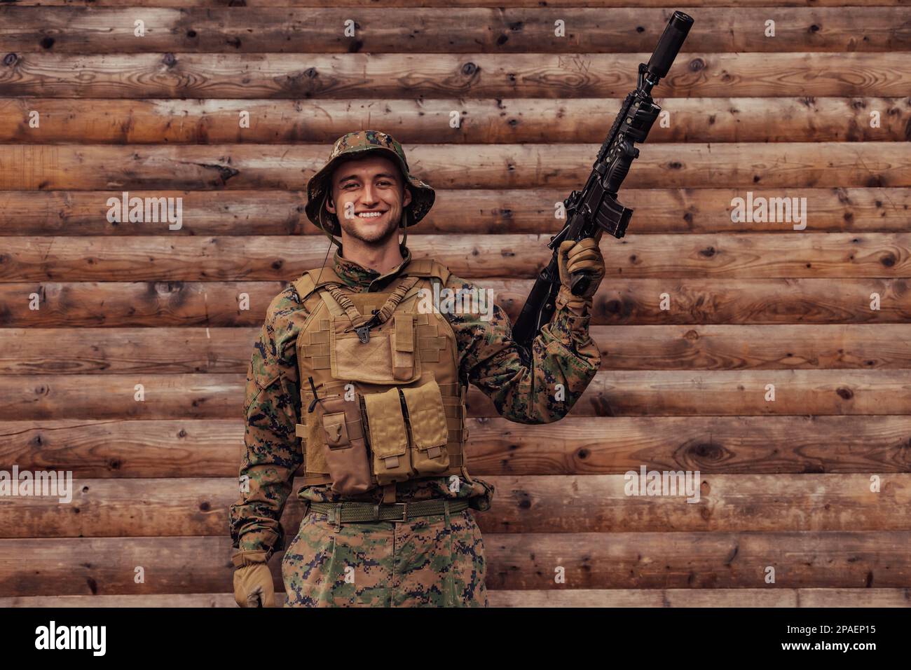A soldier in uniform with a rifle in his hand is standing in front of a ...