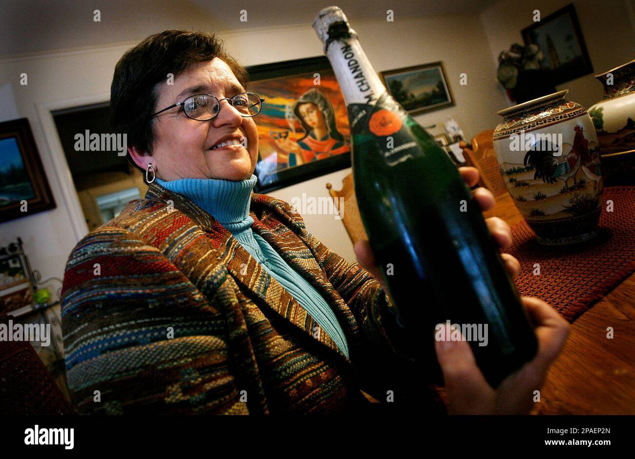 Former Cuban resident Maria Wallace holds a 35-year-old bottle of ...