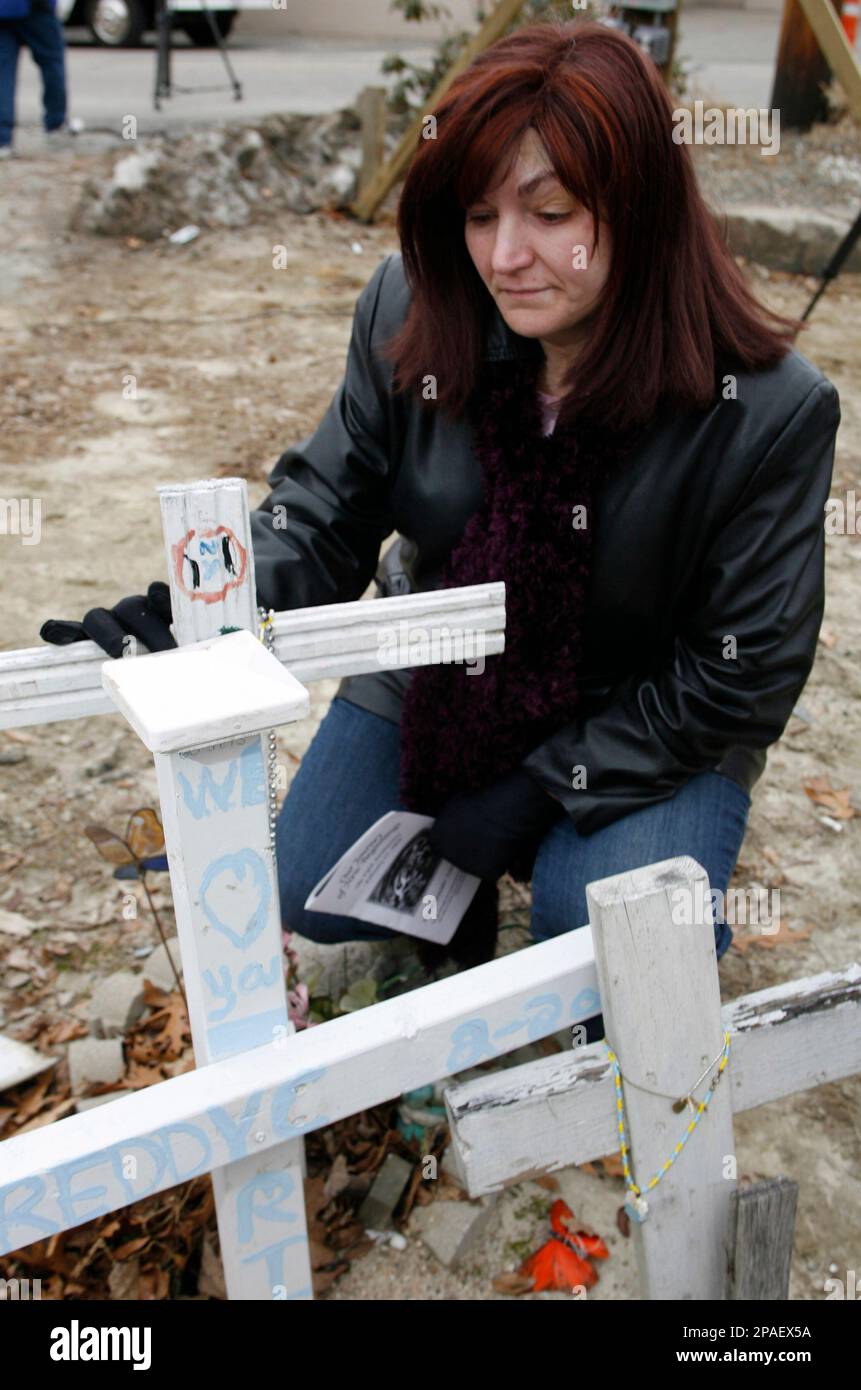 Gina Russo, of Cranston, R.I., kneels by the cross for her former boyfriend Freddy Crisostomi ...