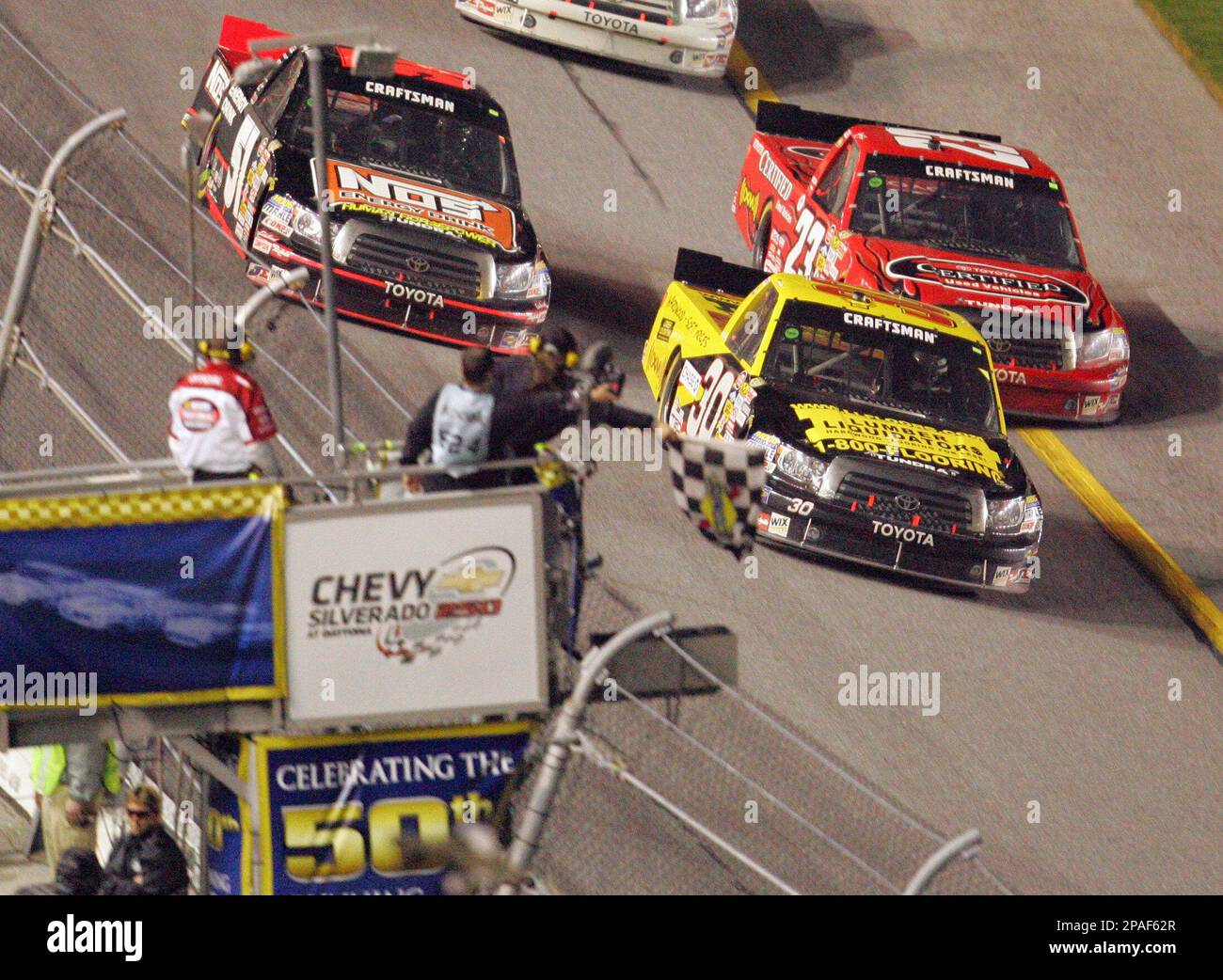 Driver Todd Bodine (30) leads Kyle Busch (51) and Johnny Benson (23 ...