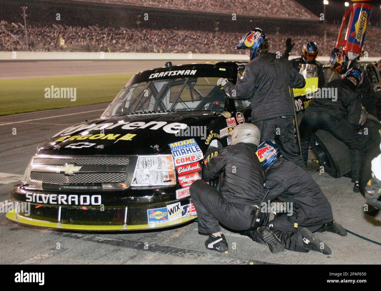 Crew members perform a pit stop on driver Marc Mitchell's truck during ...