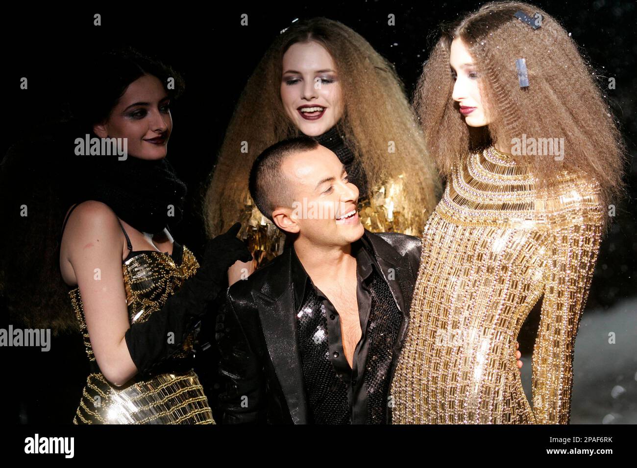 Designer Julien Macdonald, centre, walks onto the runway with his ...