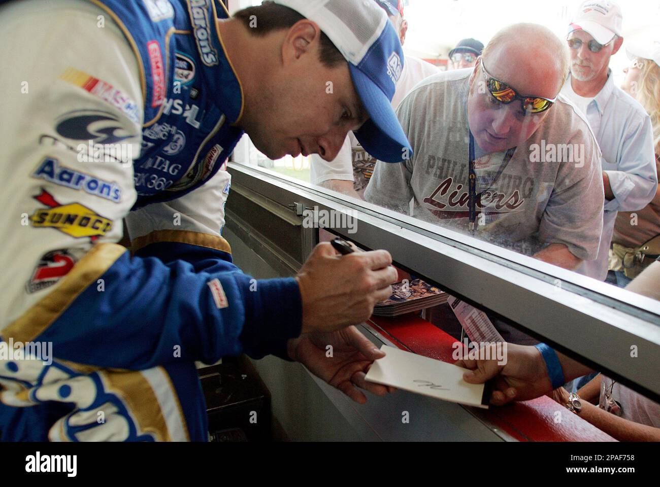NASCAR driver David Reutimann signs autographs for fans in the garage ...
