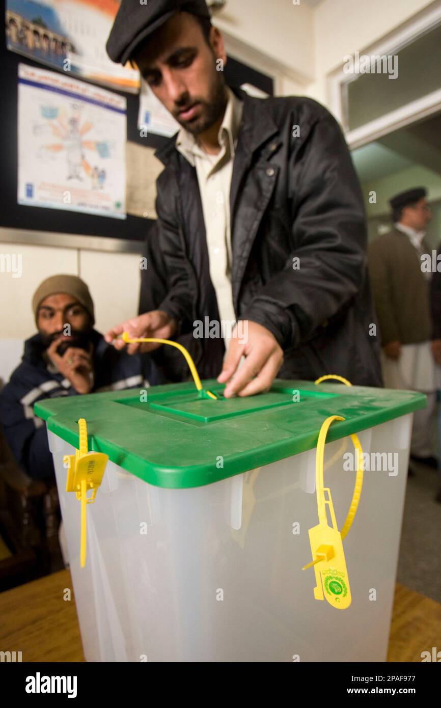 An election commission staff member demonstrates how to seal the ballet ...