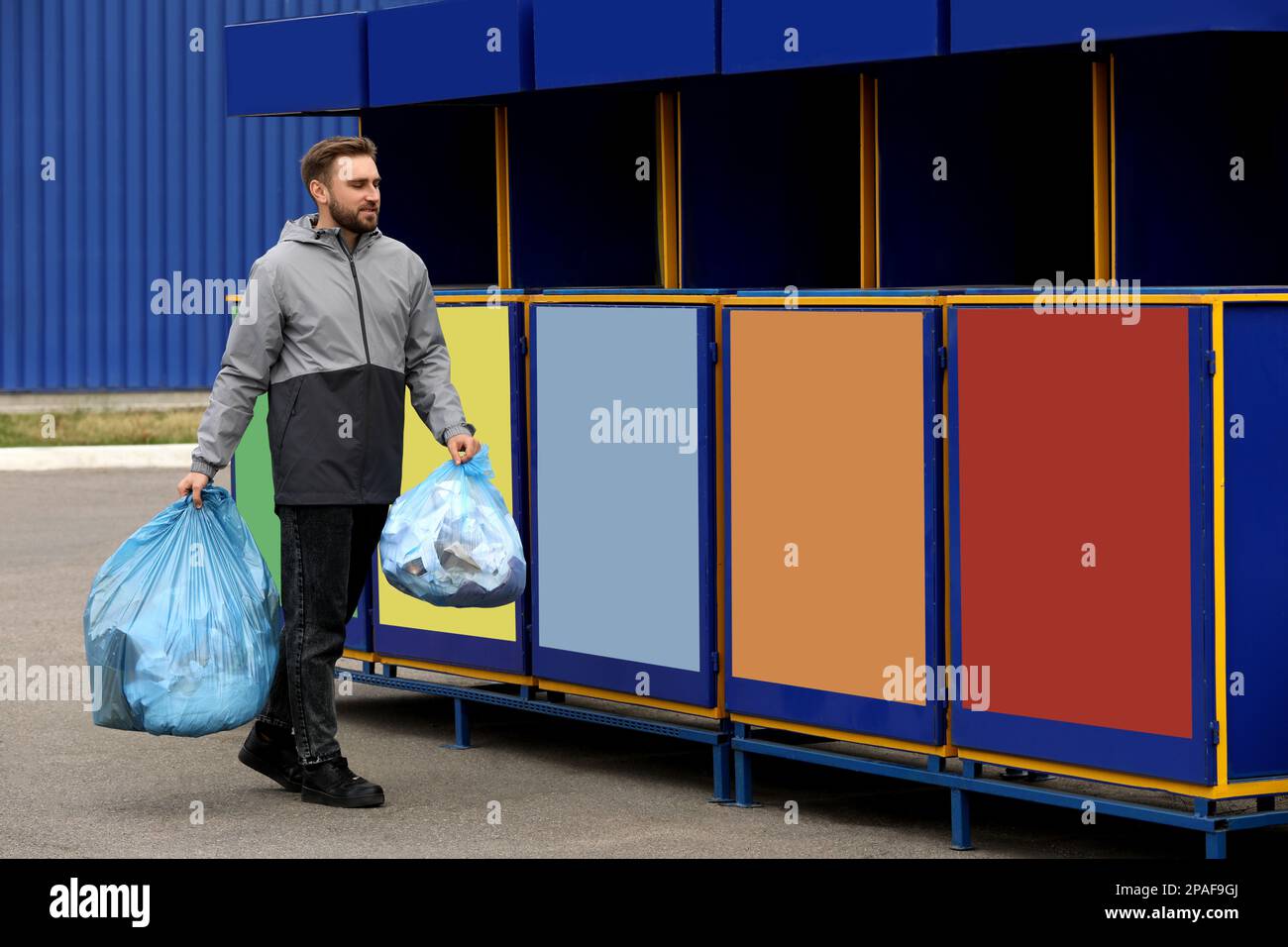 Man throwing garbage at recycling point outdoors Stock Photo - Alamy