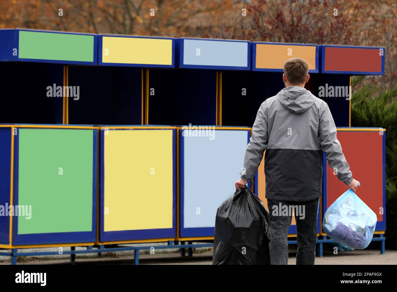 Man with garbage at recycling point outdoors, back view Stock Photo - Alamy