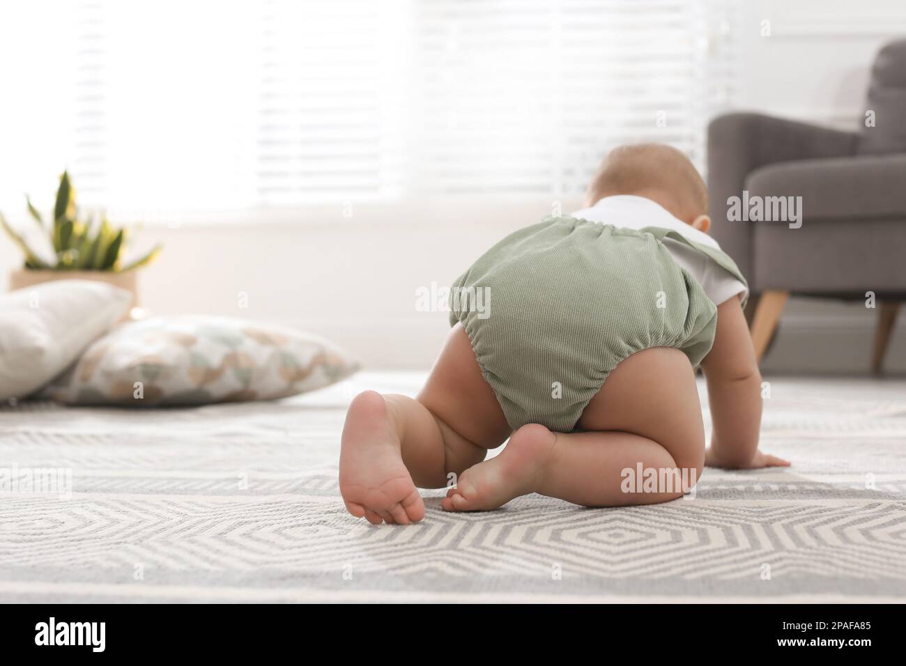 Cute baby crawling at home, focus on legs Stock Photo - Alamy