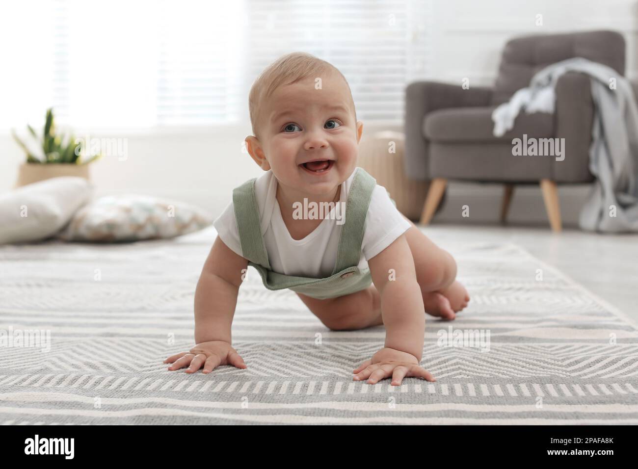 Cute baby crawling on floor at home Stock Photo - Alamy