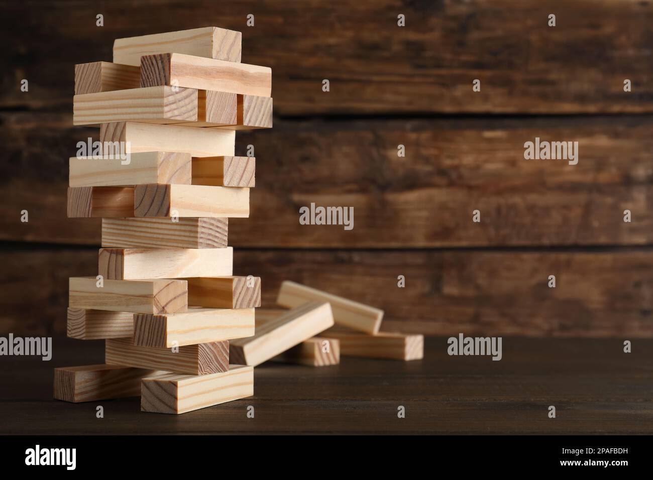 Jenga tower made of wooden blocks on table, space for text Stock Photo ...