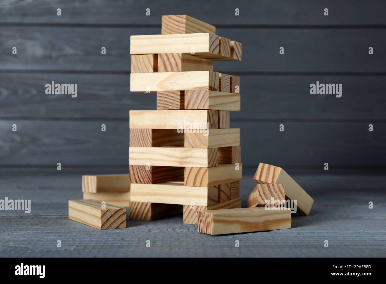 Jenga tower and wooden blocks on grey table. Board game Stock Photo - Alamy