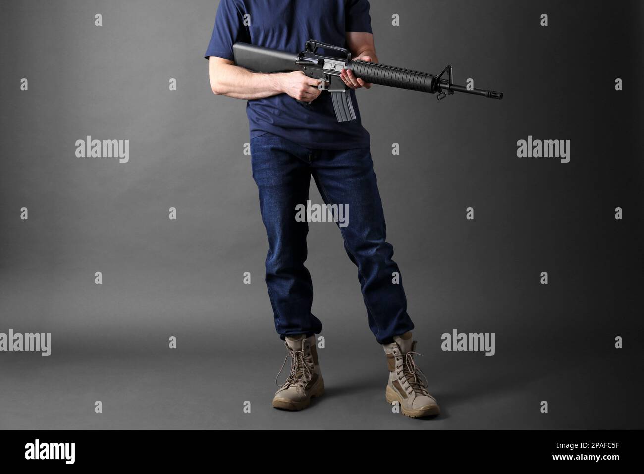 Assault gun. Man holding rifle on dark background, closeup Stock Photo ...