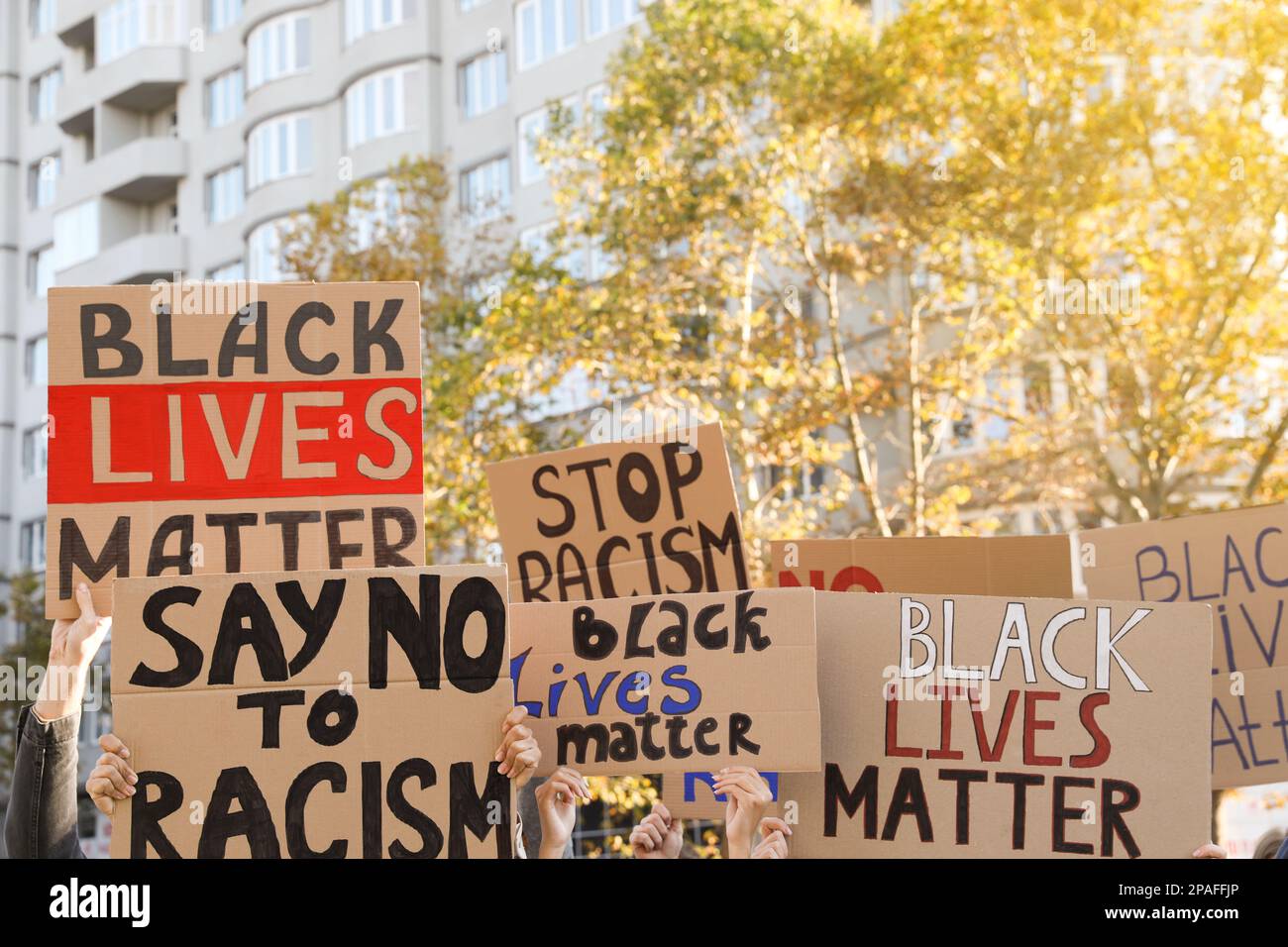 Protesters demonstrating different anti racism slogans outdoors. People ...