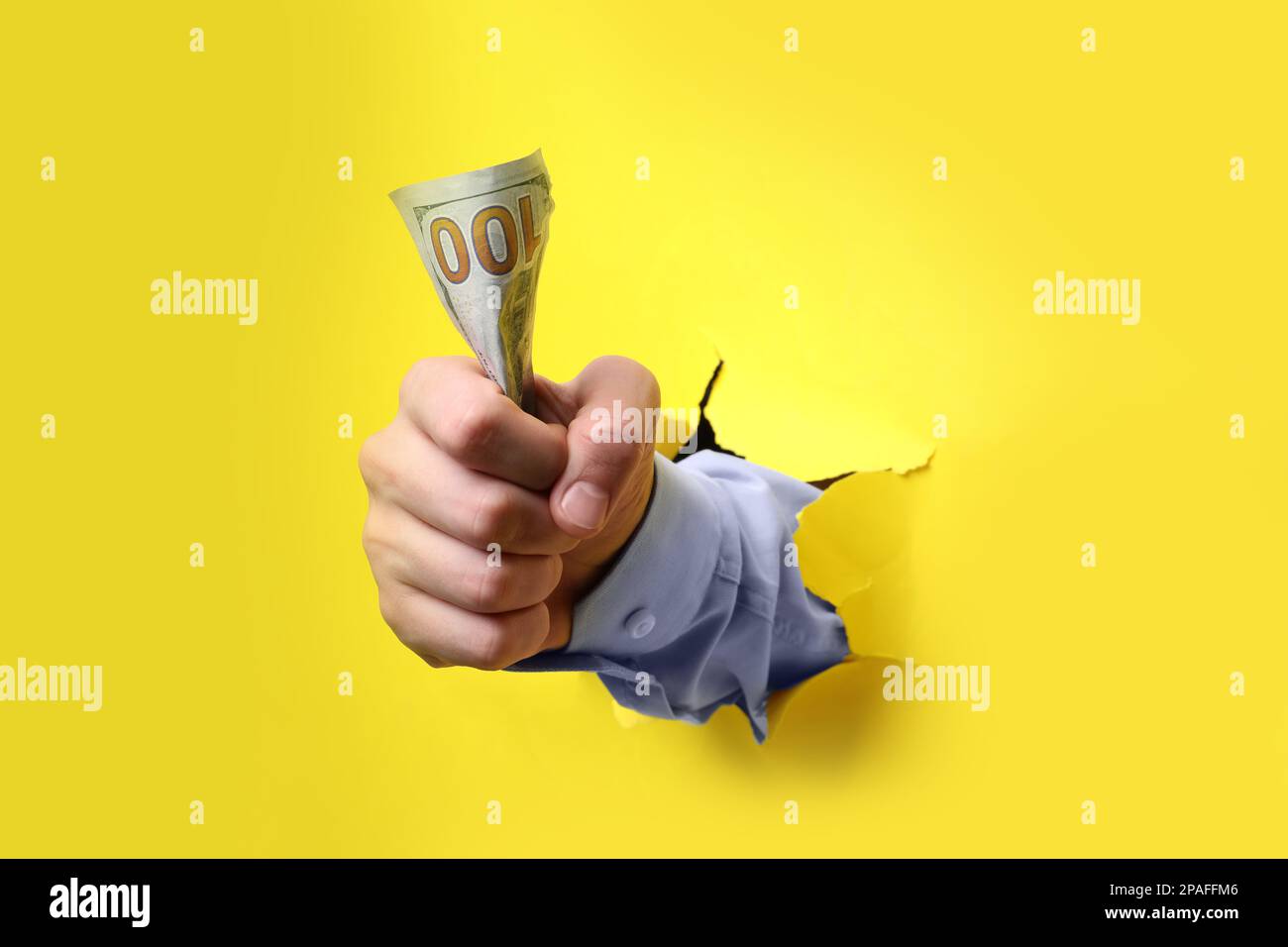 Hand breaking through paper holding hi-res stock photography and images ...