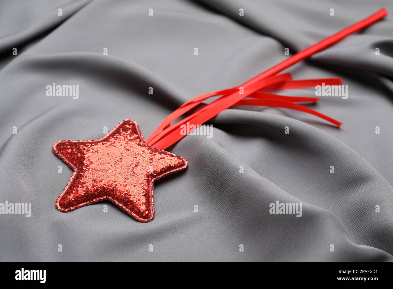 Beautiful red magic wand on grey fabric Stock Photo - Alamy