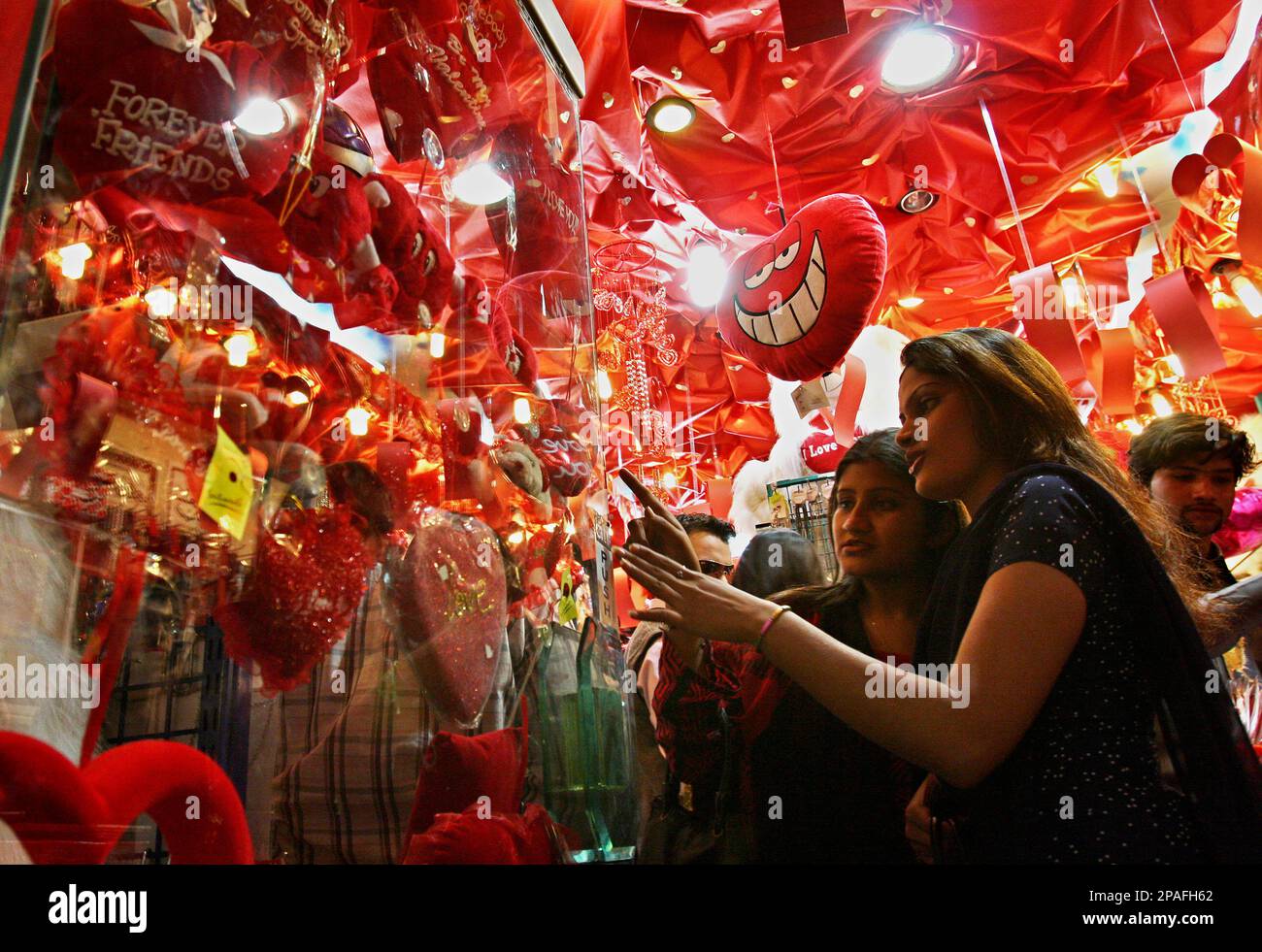 Pakistani girls look Valentine's Day merchandise at a shop in port city ...