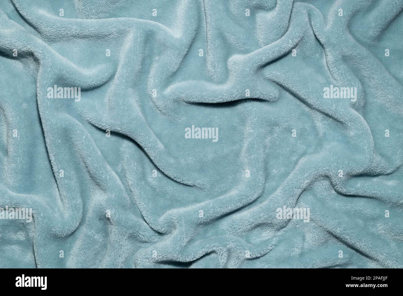 Wavy soft blue fabric texture background, made with Blanket. Top view with Copy space. Minimal ...