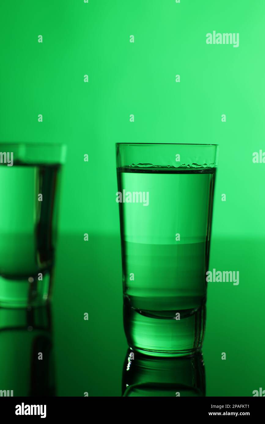 Vodka on table against green background, space for text Stock Photo - Alamy