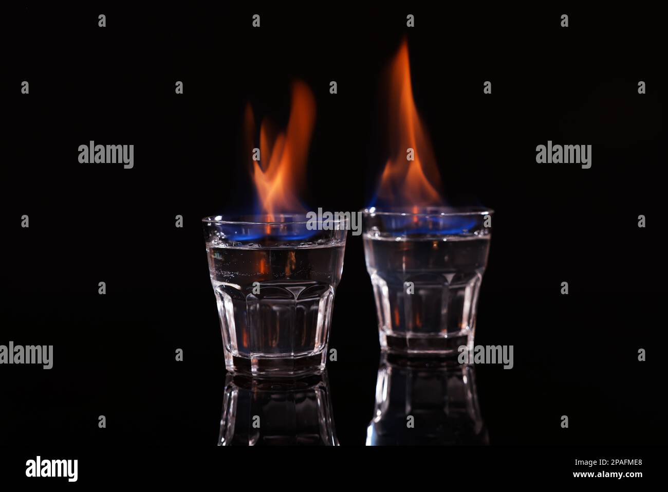 Flaming vodka in shot glasses on black background Stock Photo - Alamy