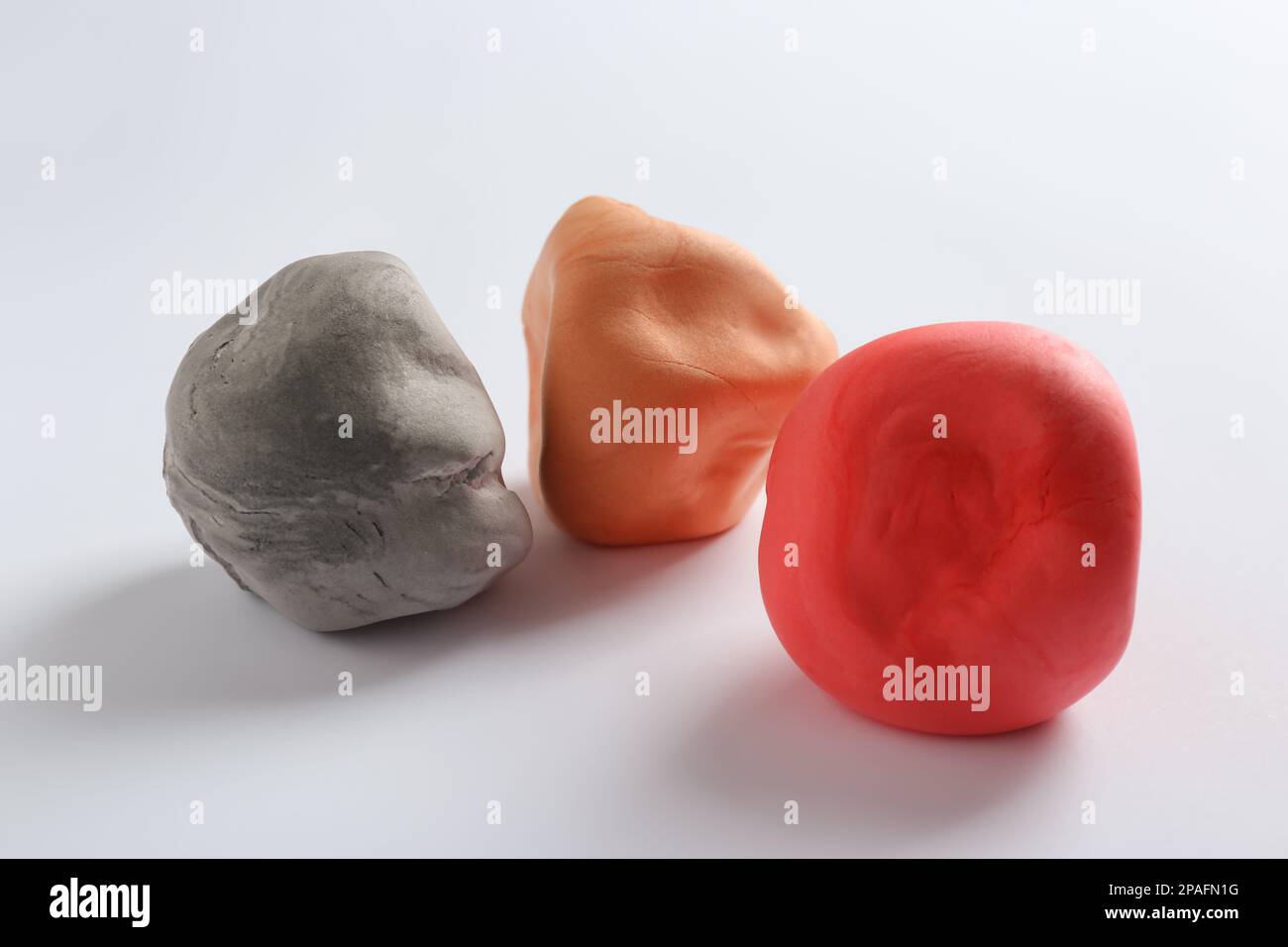 Different color play dough on white background Stock Photo - Alamy