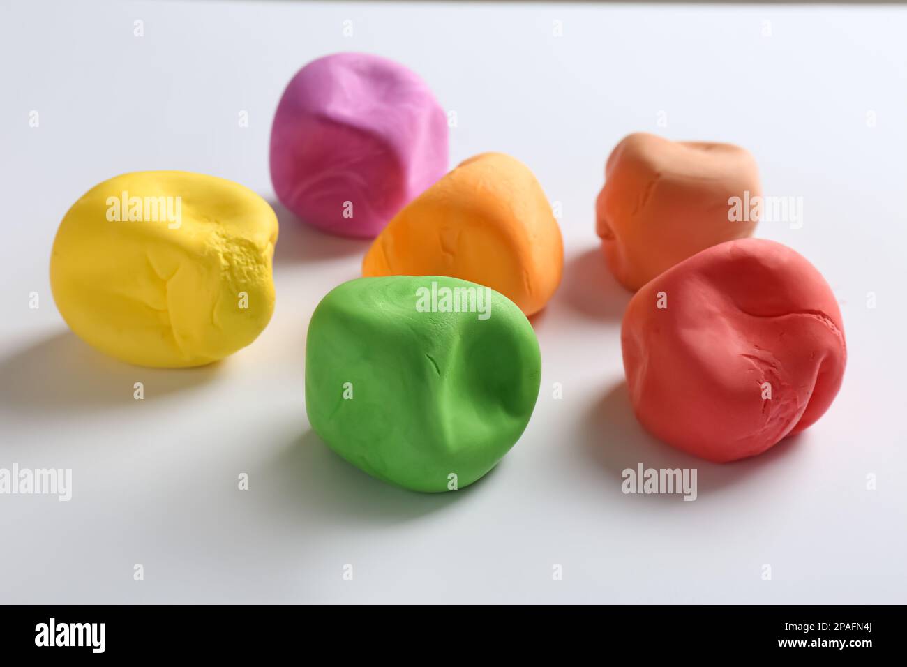 Different color play dough on white background Stock Photo - Alamy