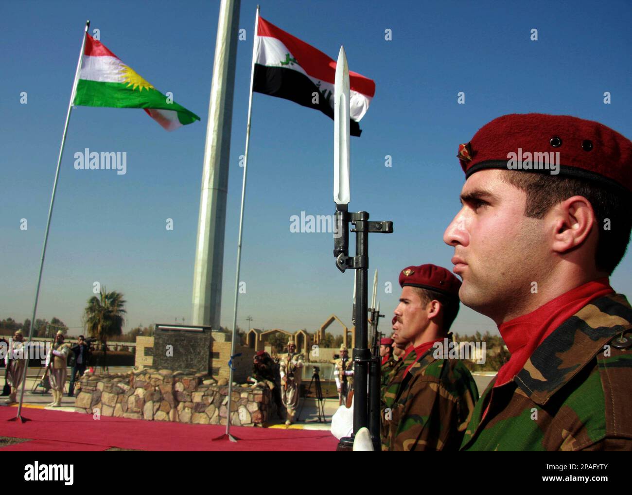 The new Iraqi flag, right, flies next to the Kurdish flag during a flag ...