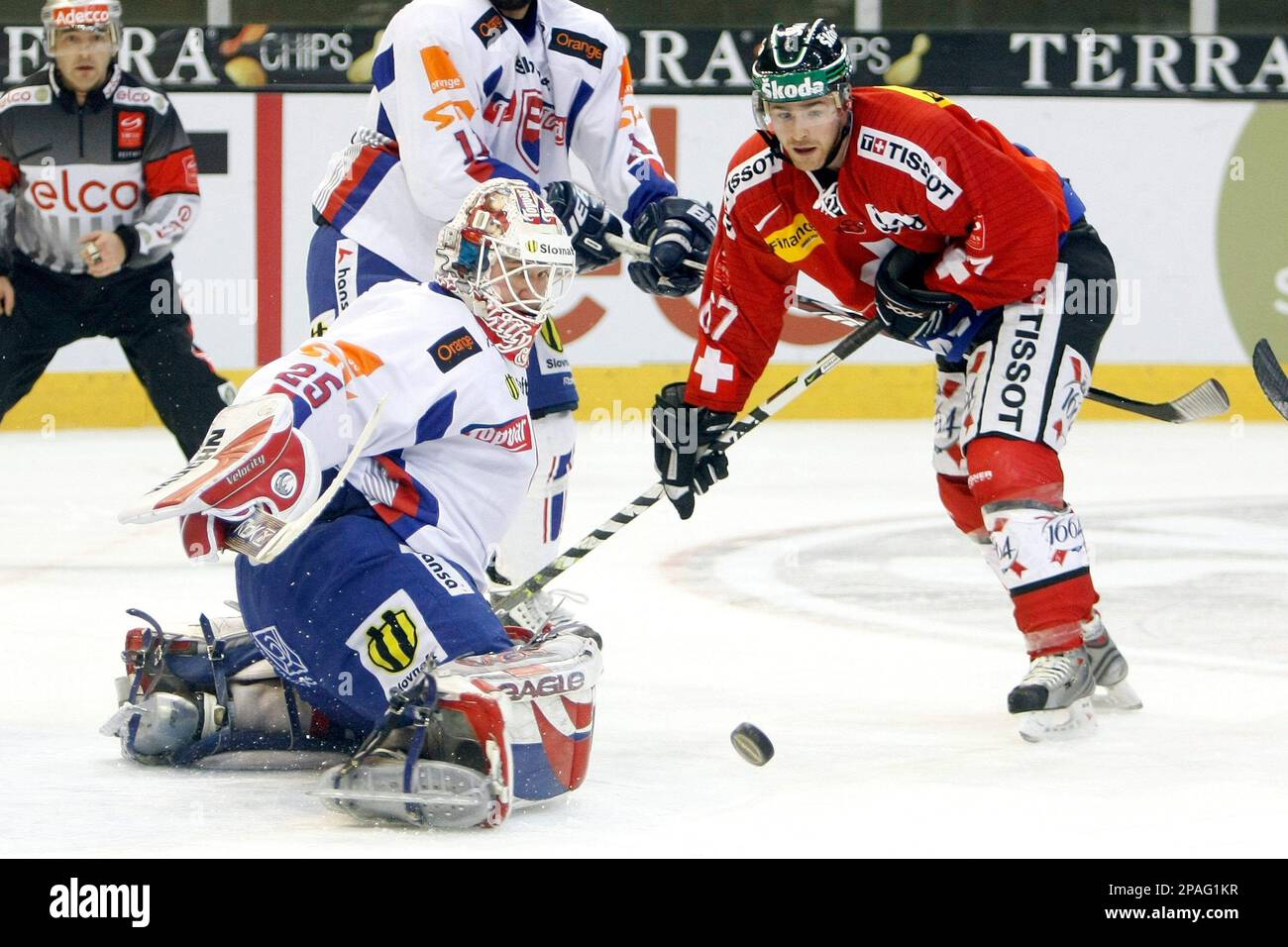 Slovakian goalkeeper Jan Lasak, left, fights for the puck with Swiss ...