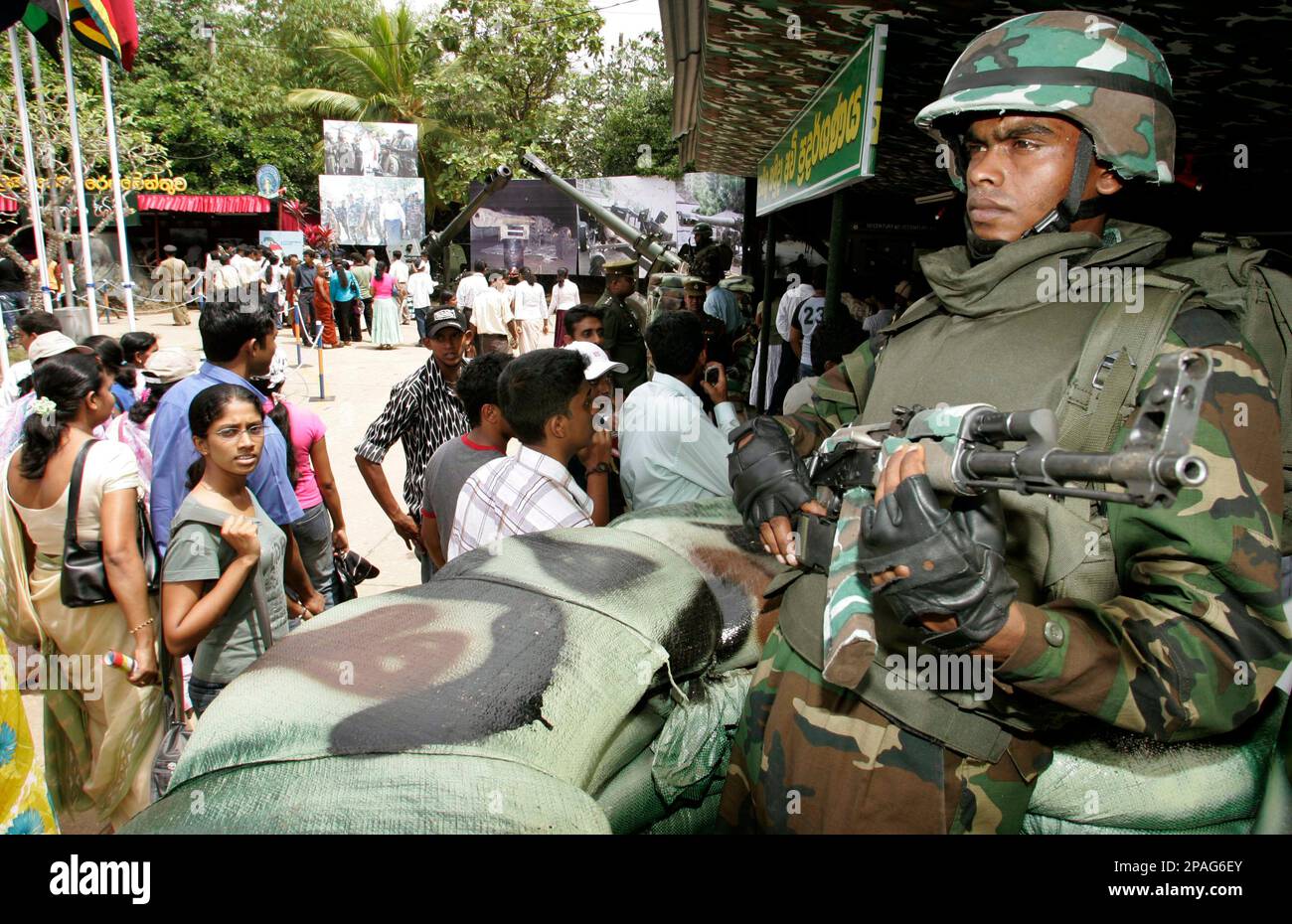 Soldier stands guard as Sri Lankan public gather around a army stall ...