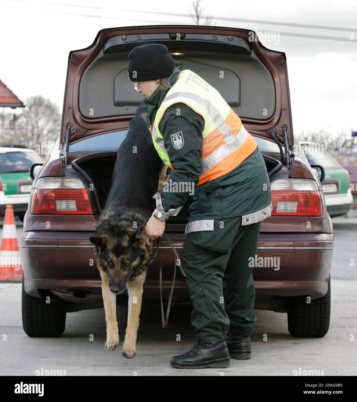 Eine Polizeibeamter untersucht mit einem Rauschgiftspuerhund einen ...