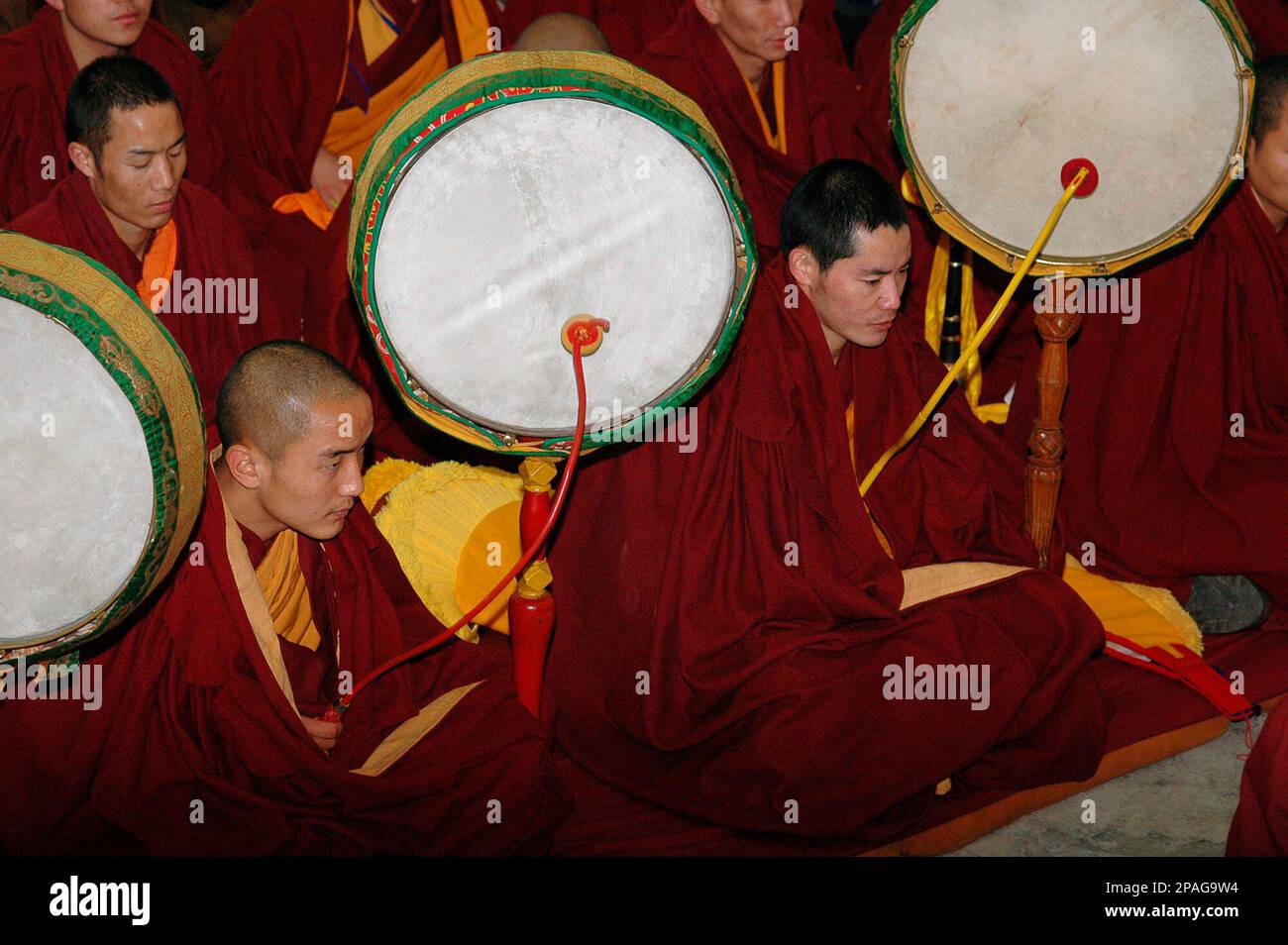 Tibetan Buddhist monks beat ceremonial drums at a morning prayer ...